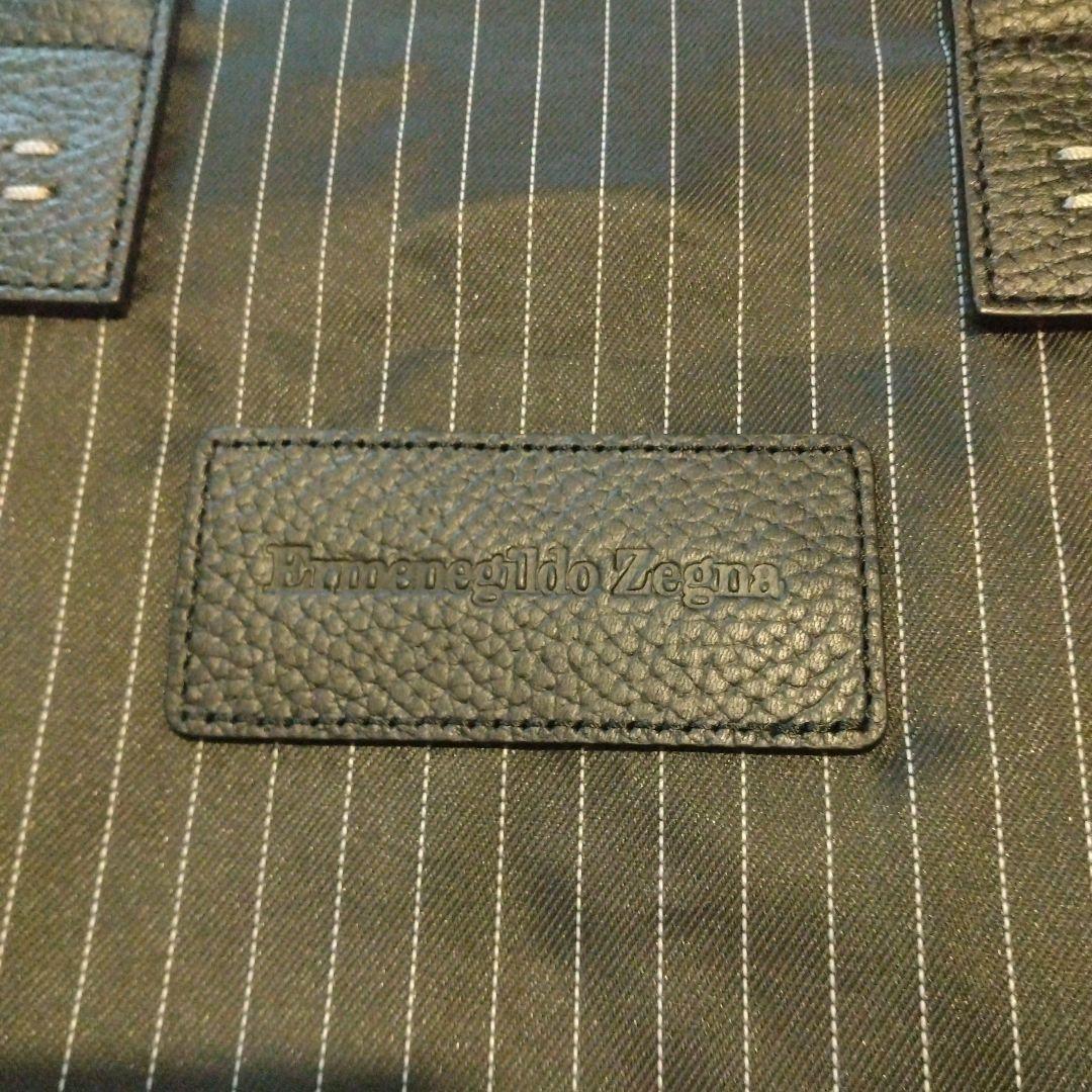 ZEGNA ストライプデザインの黒色ガーメントケース、レザー製ハンドル付き。